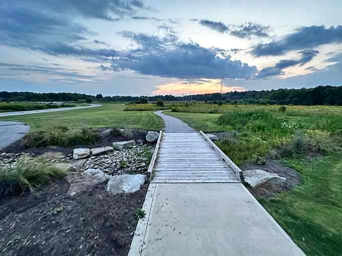 A wooden boardwalk stretching toward a painted sunset sky, Frohring Meadows reminds you that stillness is its own reward.