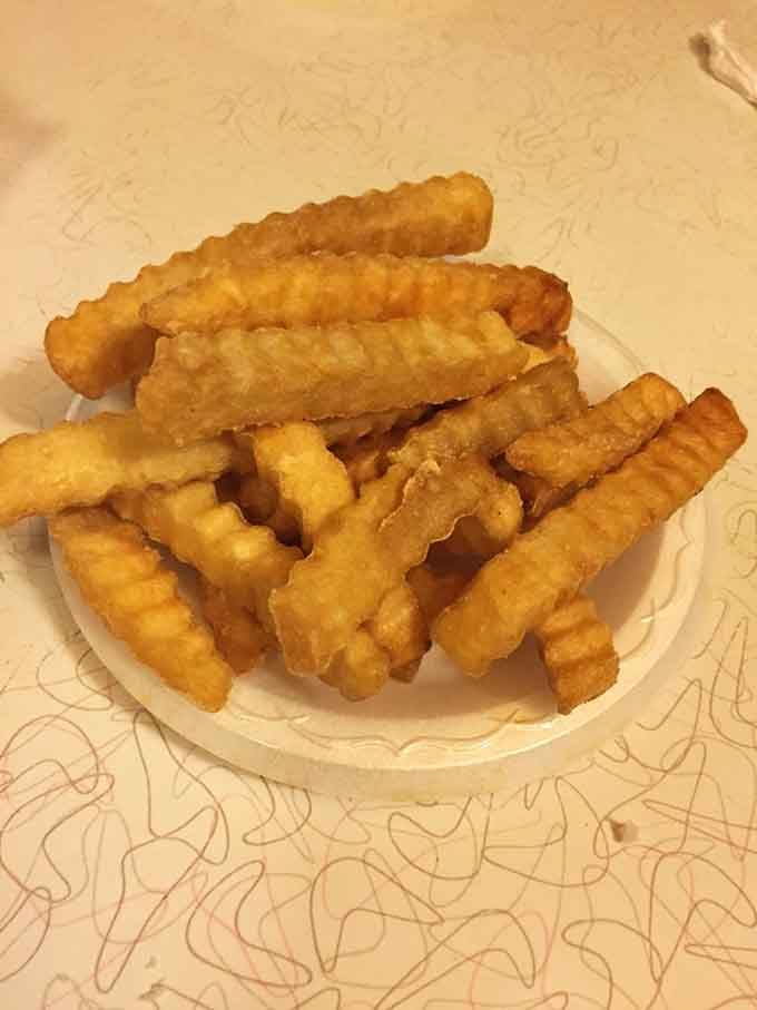 Crinkle-cut fries with that perfect golden ratio of crispy exterior to fluffy interior, the supporting actor that steals scenes.