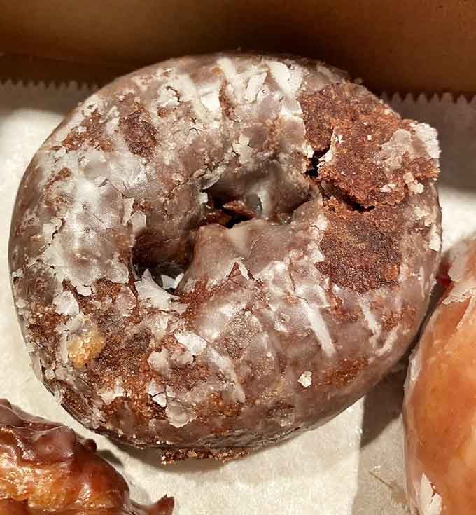 Chocolate cake donut with glaze so generous it practically demands a napkin strategy before eating.