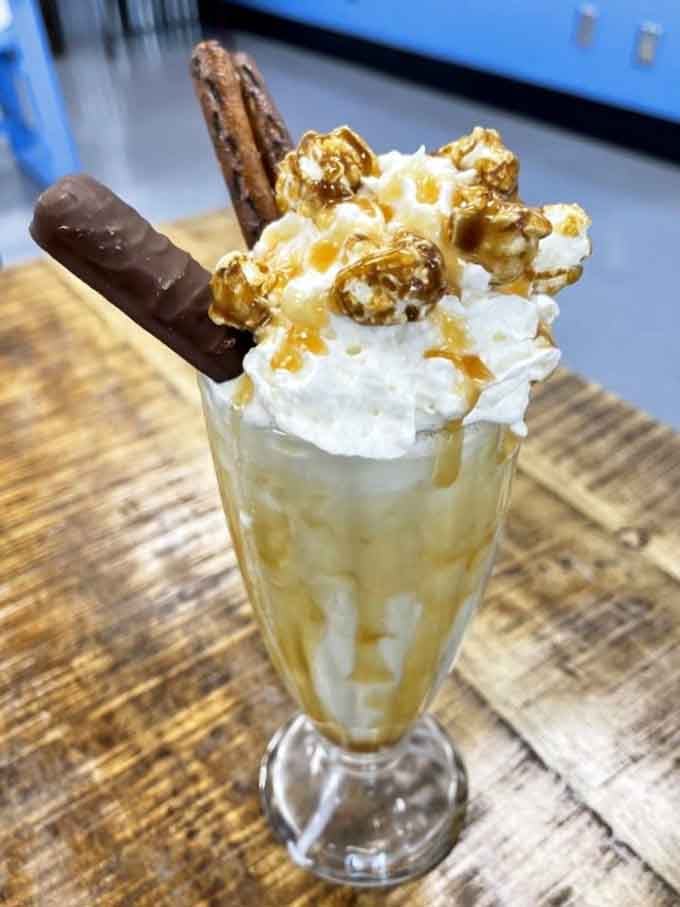 Caramel drizzle cascades down this golden beauty like liquid sunshine meeting fresh dairy heaven.