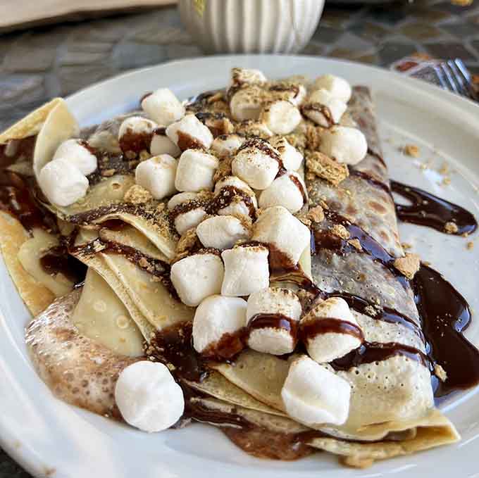 Marshmallows, graham crackers, and chocolate sauce create campfire nostalgia without the mosquitoes or smoke inhalation.