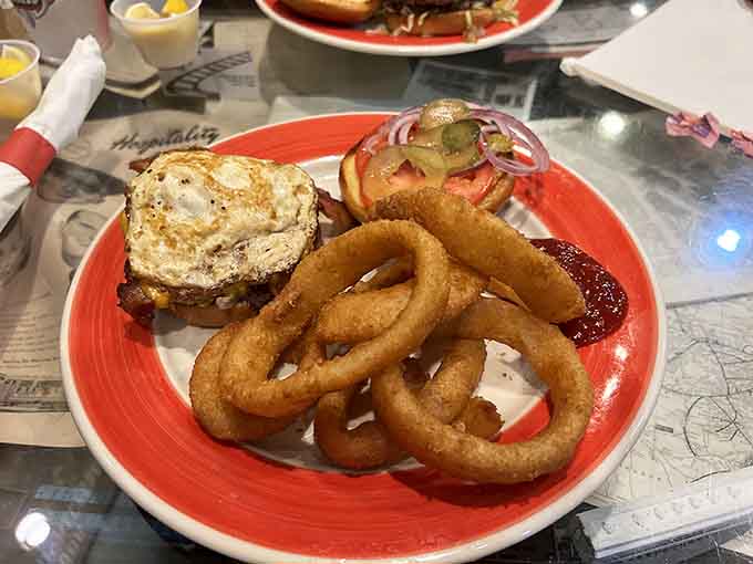 Golden onion rings so perfect they deserve their own spotlight on a red plate stage.