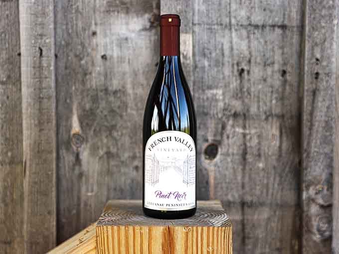 A single bottle of Pinot Noir posed on weathered wood proves that sometimes simplicity is the most sophisticated statement.