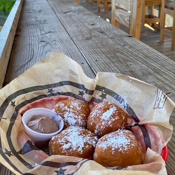 Beignets dusted with powdered sugar, served with chocolate dipping sauce and a side of swamp ambiance.