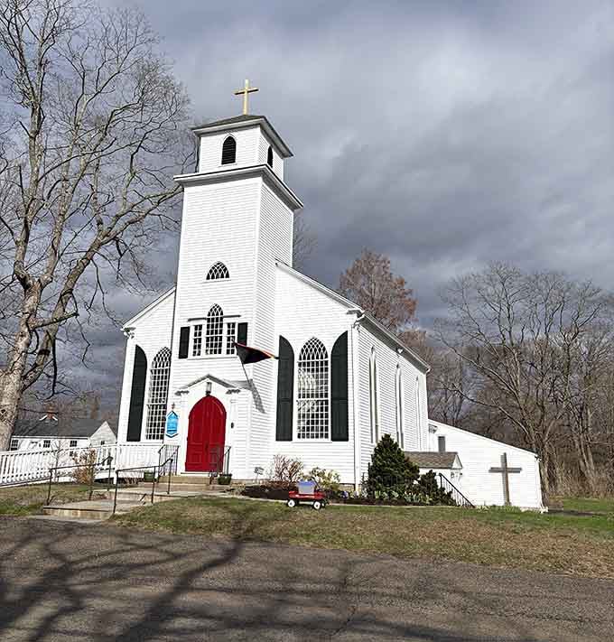 This pristine white church with its striking red door stands as a beacon of traditional New England architectural beauty.