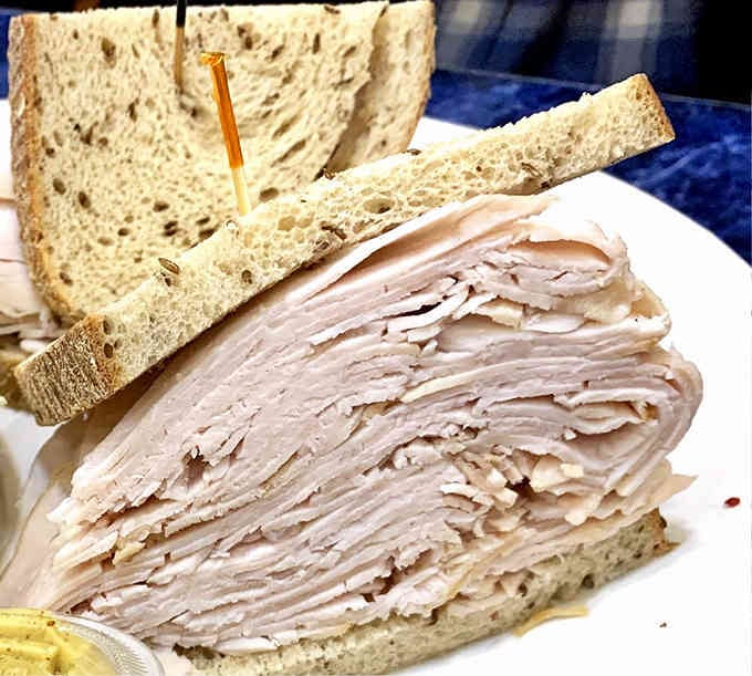 Turkey stacked so high it makes you wonder if they're compensating for something, gloriously so.