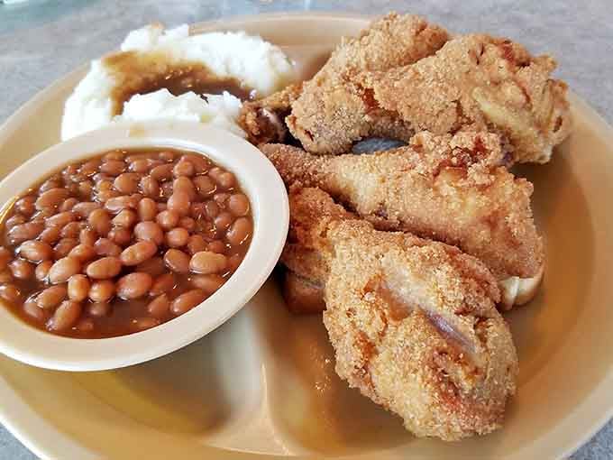 Three pieces of perfectly breaded chicken with mashed potatoes and beans prove that simple done right beats fancy every time.