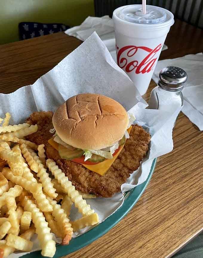 The bun looks adorably optimistic trying to contain that massive tenderloin, while those crinkle fries know their supporting role.