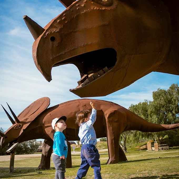 Two future paleontologists contemplate whether they could actually reach that dinosaur's nose if they really tried.