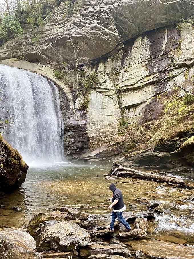 Someone testing the waters while the waterfall provides the world's most dramatic backdrop for contemplation.