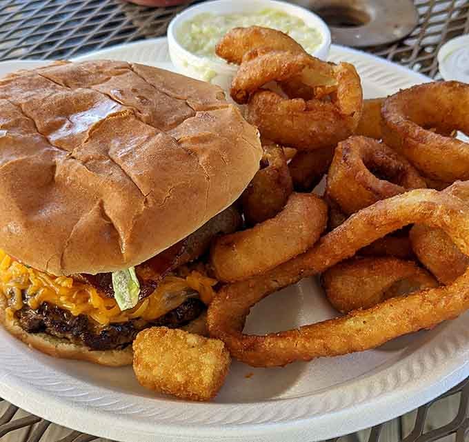 Golden onion rings surrounding a loaded burger, this plate understands what happiness looks like.