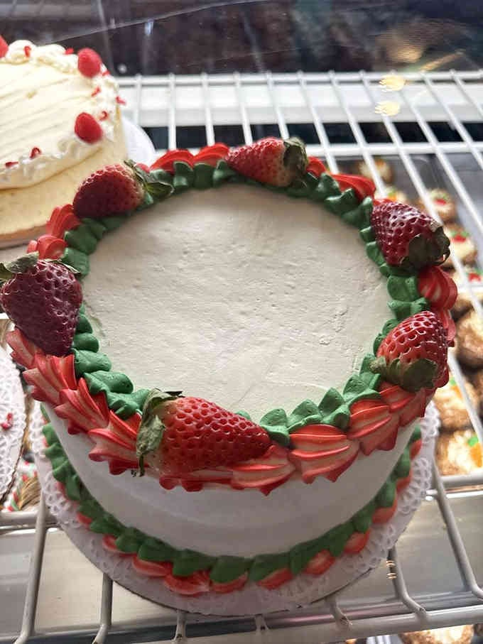 Fresh strawberries crown this beauty like nature's own edible jewelry on perfectly whipped cream frosting.