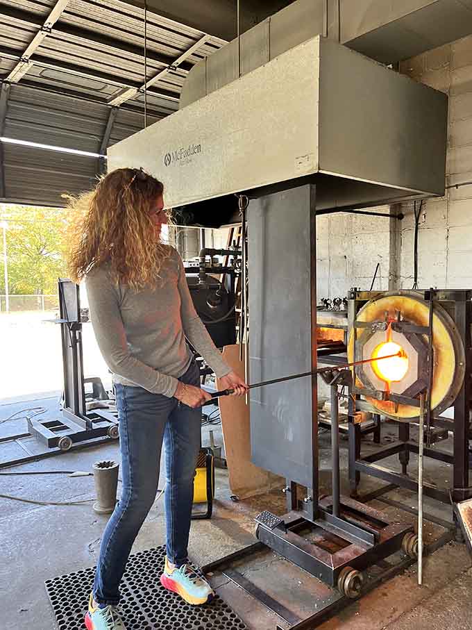 She's gathering molten glass like a pro, proving this ancient craft welcomes brave souls of all backgrounds.