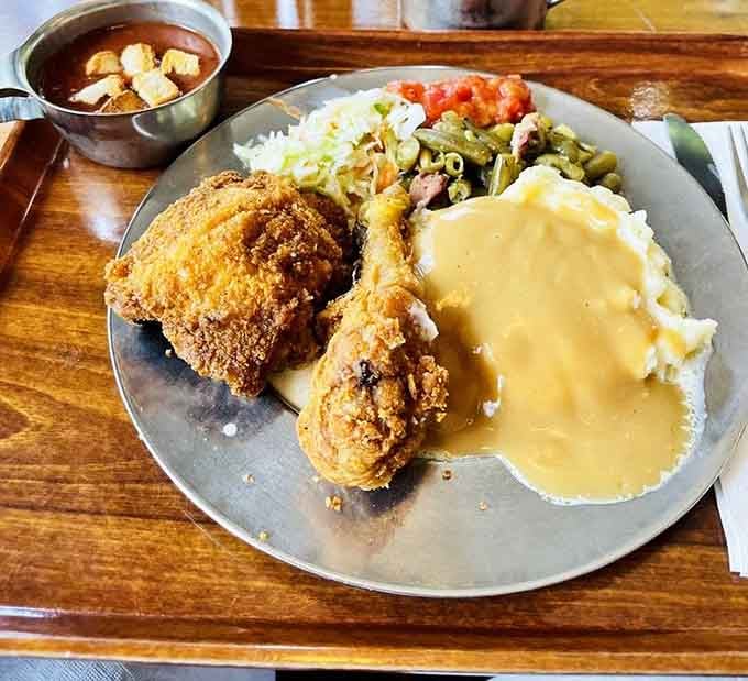 Golden fried chicken surrounded by its supporting cast of mashed potatoes, green beans, and coleslaw perfection.