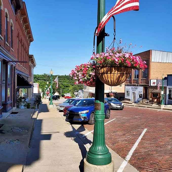 Flower baskets bursting with color against Old Glory, small-town pride displayed without a hint of pretension.