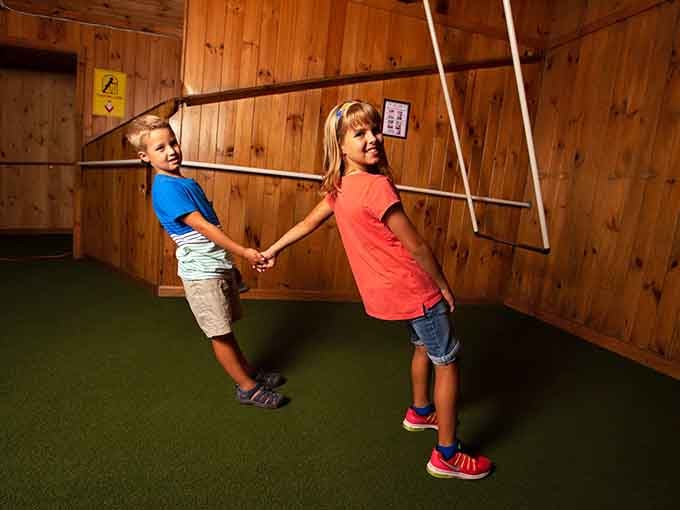 Two kids, one tilted room, and absolutely zero understanding of how they're standing like that without toppling over completely.