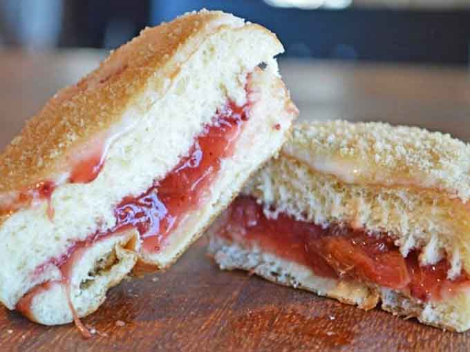 That jelly-filled cross-section reveals layers of flaky perfection that would make any pastry chef weep with envy.