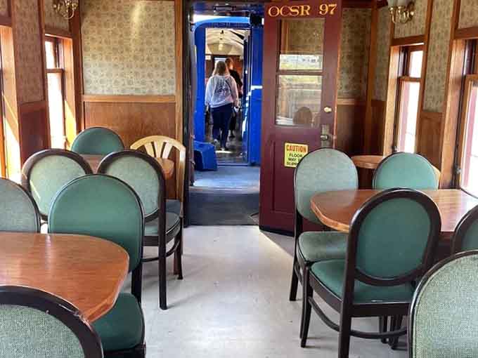 The dining car's green chairs and wooden tables offer a civilized way to enjoy the journey in classic style.
