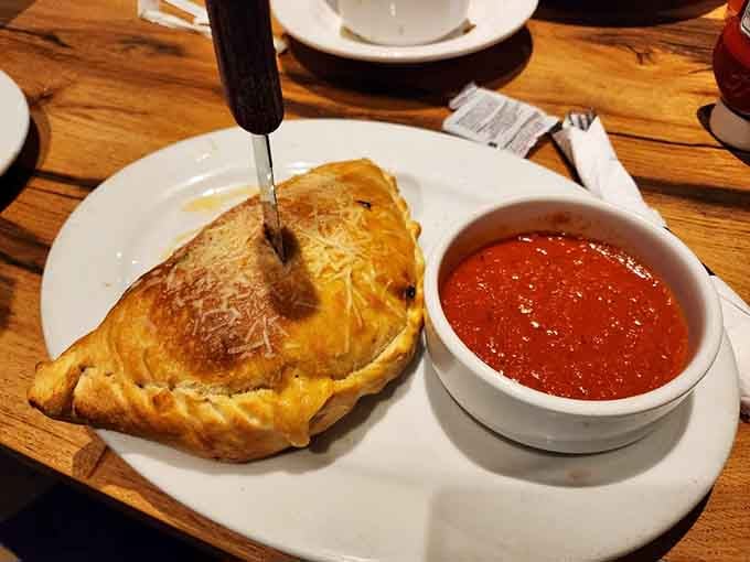 That calzone is stuffed so generously it could probably qualify as carry-on luggage, if airports allowed delicious contraband.