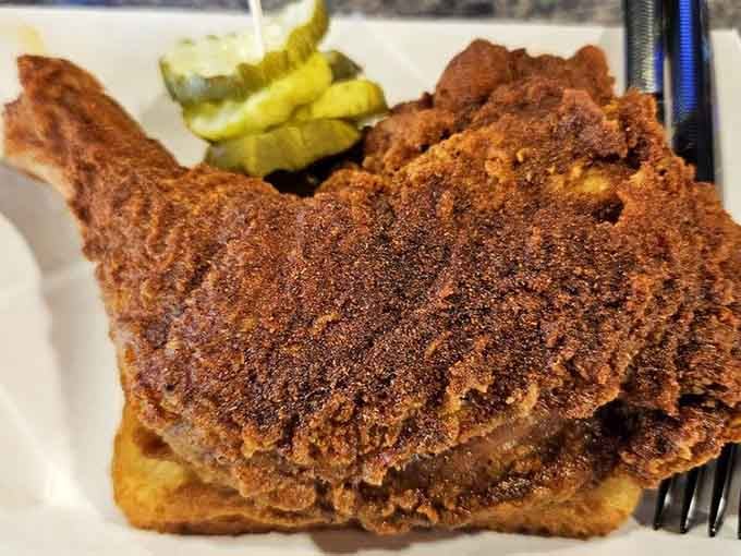 Look at that mahogany crust glistening with spice, perched on Texas toast like it owns the place, because it does.