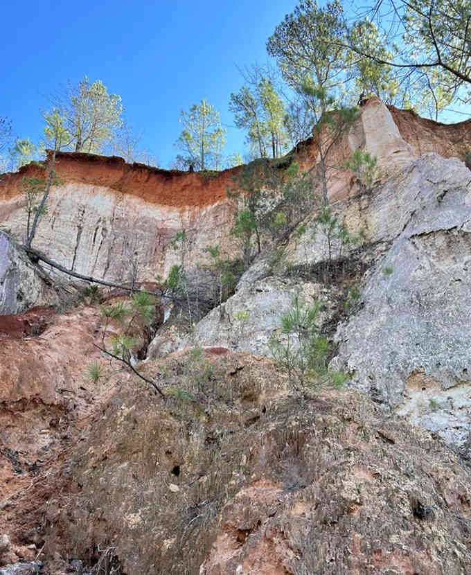 Rust-red clay meets pale sediment in dramatic vertical stripes, like nature decided to paint with earth tones.