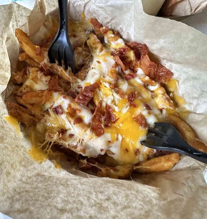 Loaded fries buried under melted cheese, bacon bits, and ranch create the kind of indulgence that makes diets take a vacation.