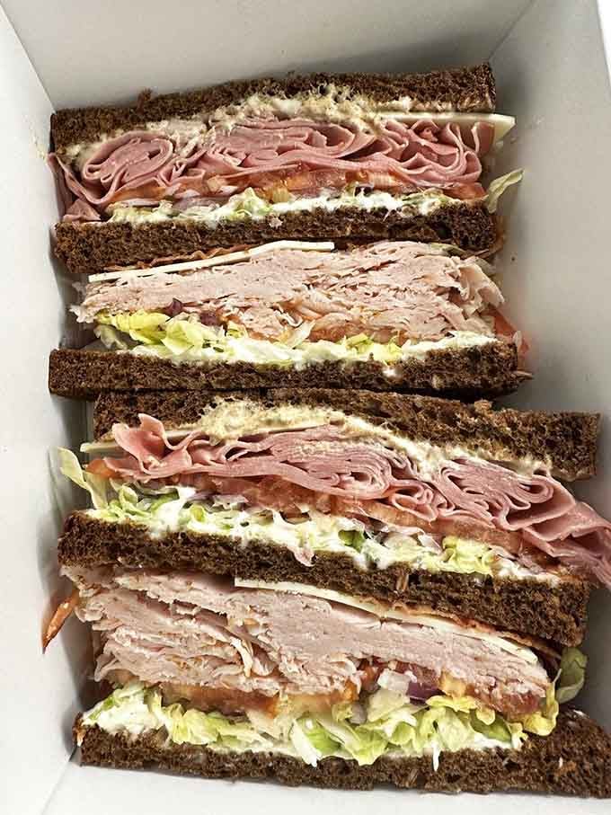 Layers of turkey, bacon, and lettuce stacked like a delicious Jenga tower that everyone wants to topple.