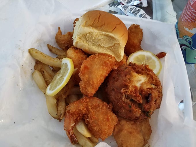Golden fried seafood with crispy edges, soft bun, lemon wedges, and fries creates the perfect beachside feast for your soul.