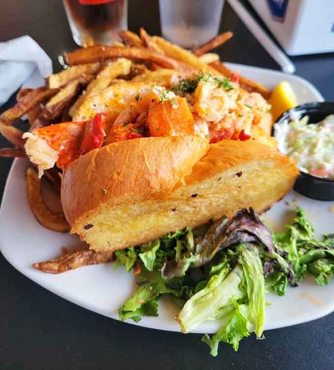 That lobster roll sits pretty like it just arrived from Maine, complete with fries for maximum happiness.
