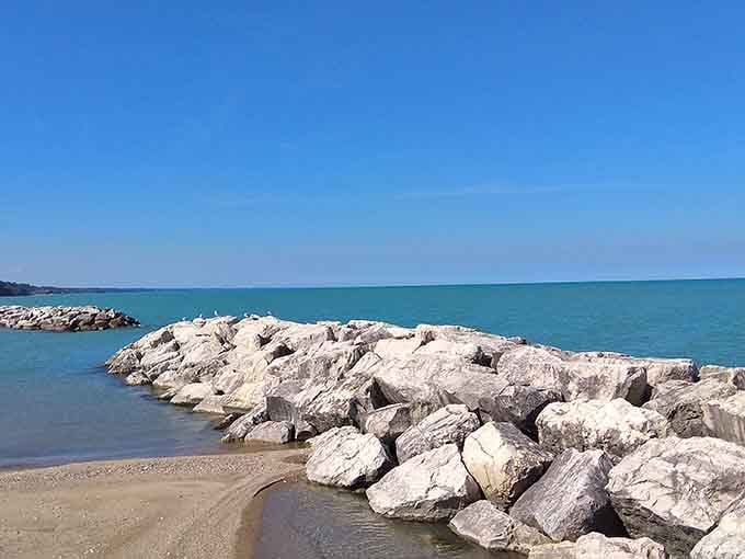 The breakwater rocks create a natural barrier, turning wild lake waves into something your grandmother would approve of.