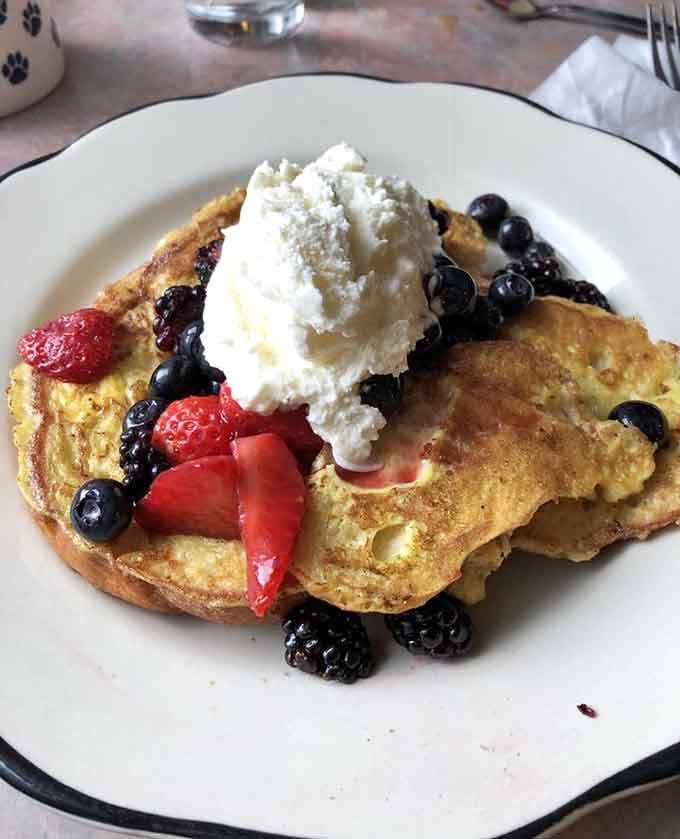 Stuffed French toast topped with berries and whipped cream proves that sometimes excess is absolutely necessary for happiness.