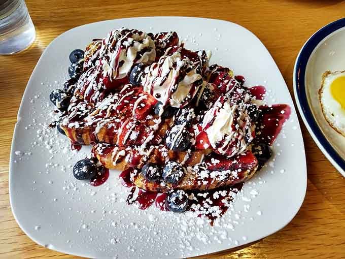French toast dressed to impress with fresh berries, chocolate drizzle, and enough powdered sugar to make your inner child very happy.