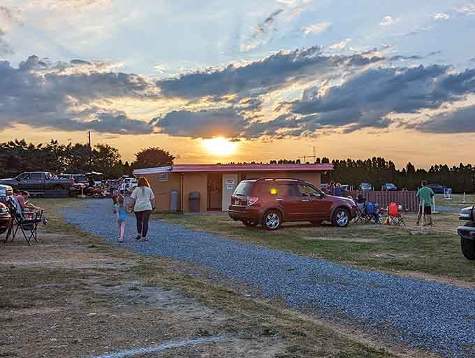 Golden hour at the drive-in creates the perfect backdrop as moviegoers settle in for an unforgettable evening.
