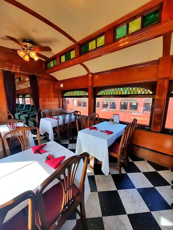 White tablecloths and wooden paneling create an elegant dining experience while the countryside glides past your window.