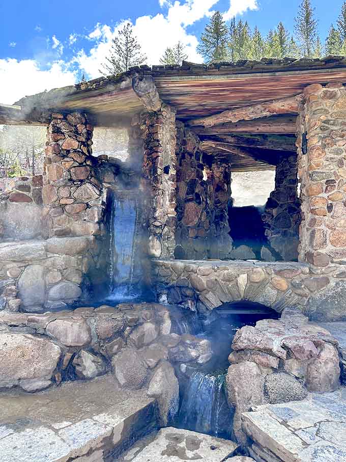 Steam rises from ancient stone structures where hot spring water flows like nature's own infinity pool design.