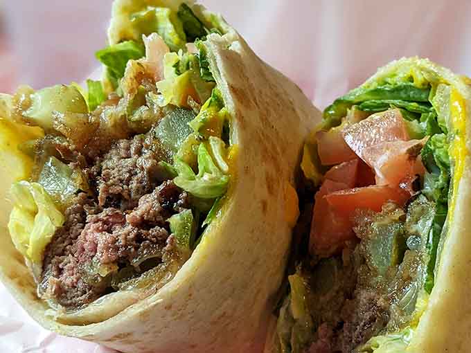 That cross-section of a loaded wrap reveals layers of seasoned beef, fresh lettuce, tomato, and cheese. Pure, glorious chaos.