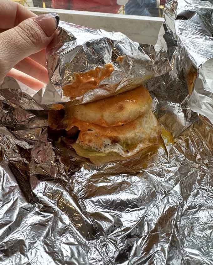 A housemade English muffin with an egg cooked just right—simple perfection never looked so good wrapped in foil.