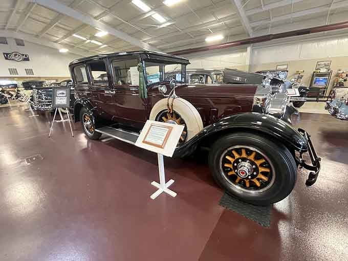 That burgundy beauty with the wooden-spoke wheels represents an era when cars were built like fine furniture.