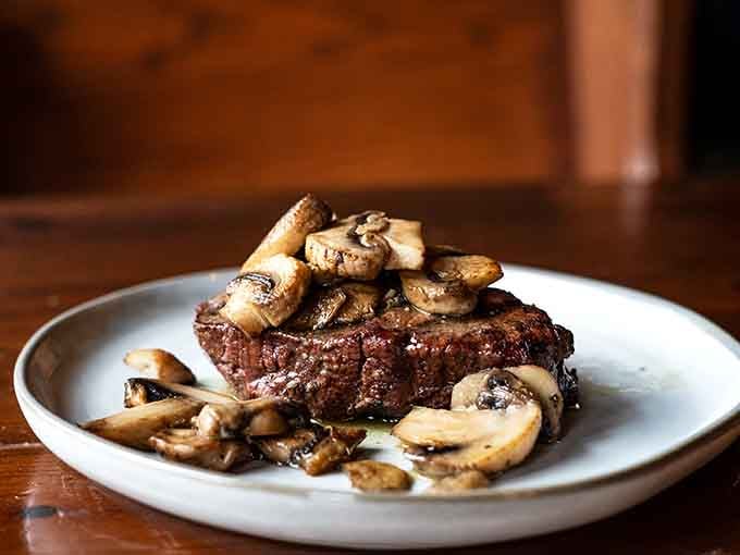 A perfectly cooked steak crowned with saut&eacute;ed mushrooms proves simplicity done right beats complexity done wrong every time.