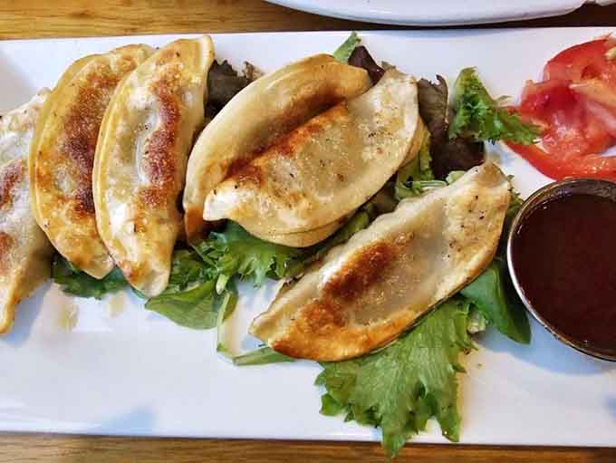 Golden potstickers lined up like edible soldiers, crispy on the outside and packed with flavor that'll make you order another round.
