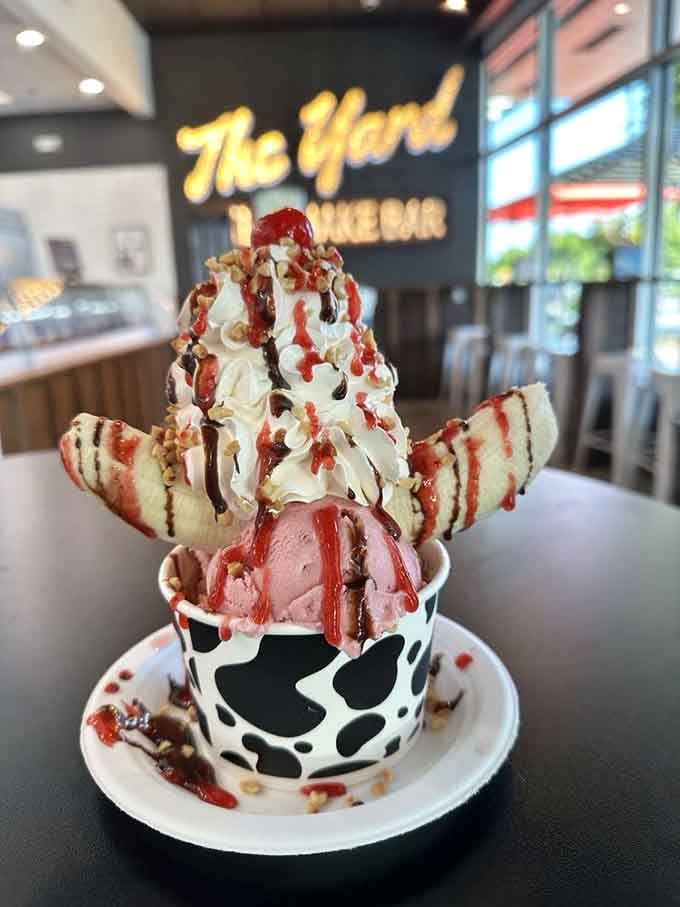 The Old School Banana Split arrives dressed to impress, strawberry drizzle, nuts, and wafer cookies fanning out like royalty.
