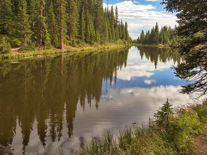 Mirror-perfect reflections on still mountain water create the kind of symmetry that makes you forget your phone exists for a moment.