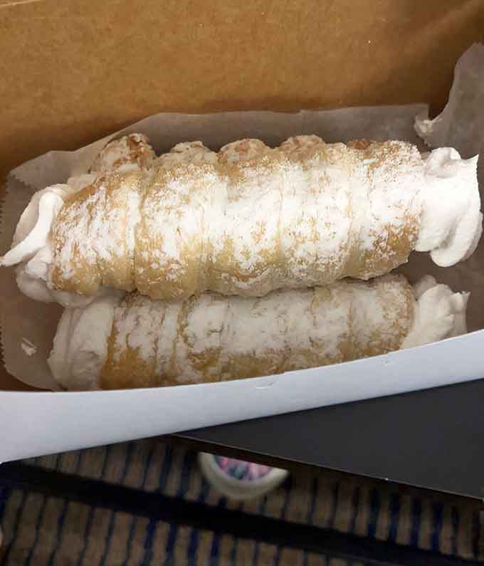 Cream horns dusted with powdered sugar, because sometimes elegance comes in a delightfully messy, delicious package.