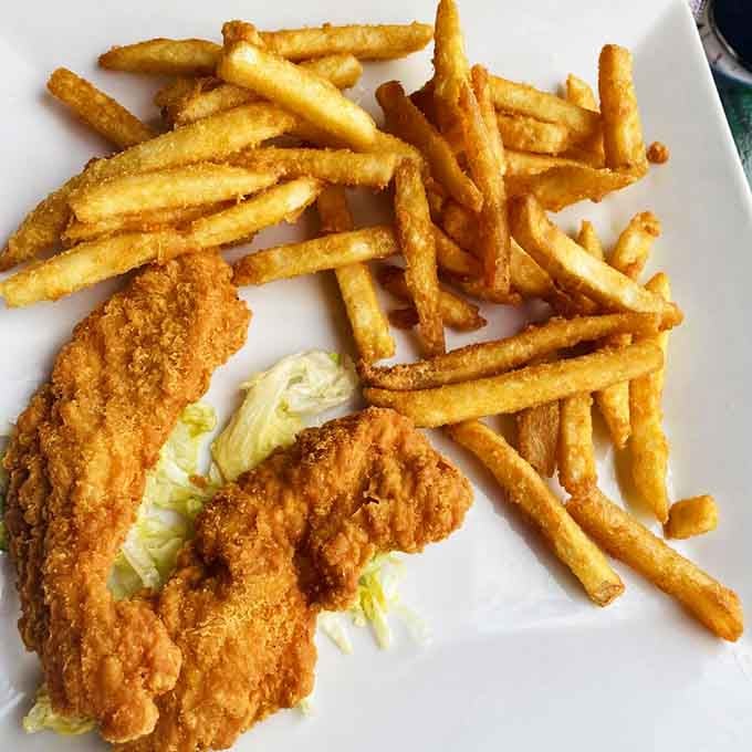 Golden chicken strips with fries that prove comfort food transcends all cultural boundaries beautifully and deliciously.