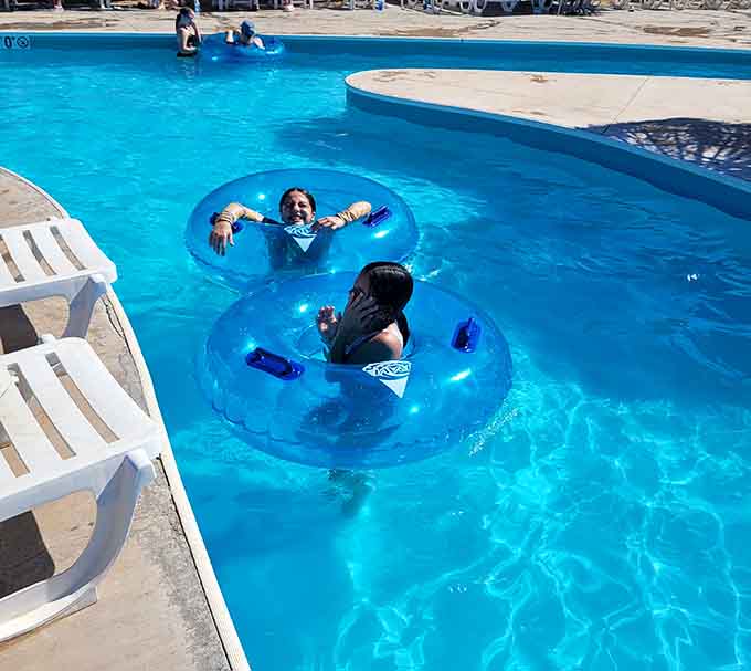 Two friends floating in blue tubes, living their best life like they're auditioning for a relaxation commercial.