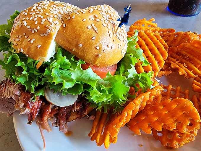 Sesame-topped bun cradling tender brisket with crispy waffle fries, lunch never looked so photogenic or delicious.