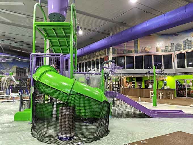 Bright green and purple slides twist overhead like something from a comic book come to life indoors.