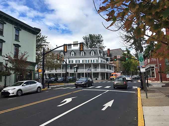 The white mansion with black shutters anchors this corner like a captain steering the neighborhood ship.