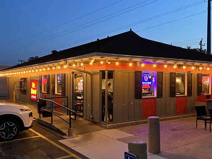 When twilight falls and those string lights glow, this corner becomes pure magic for hot dog lovers.