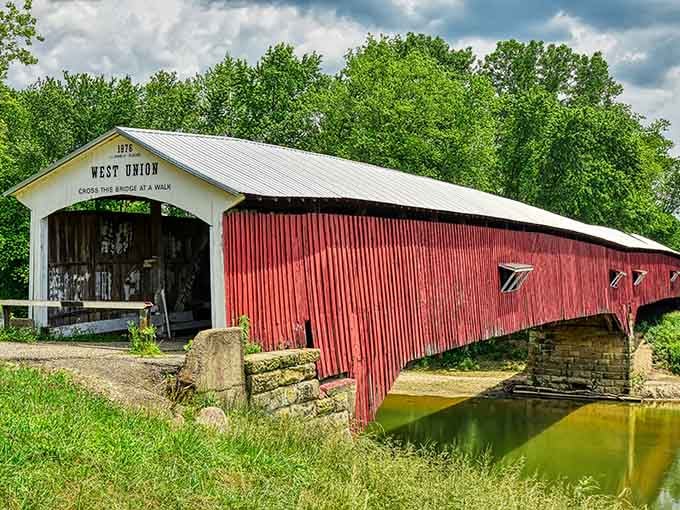 Vibrant red corrugated siding stretches endlessly, making this bridge look like a barn decided to take a stroll.